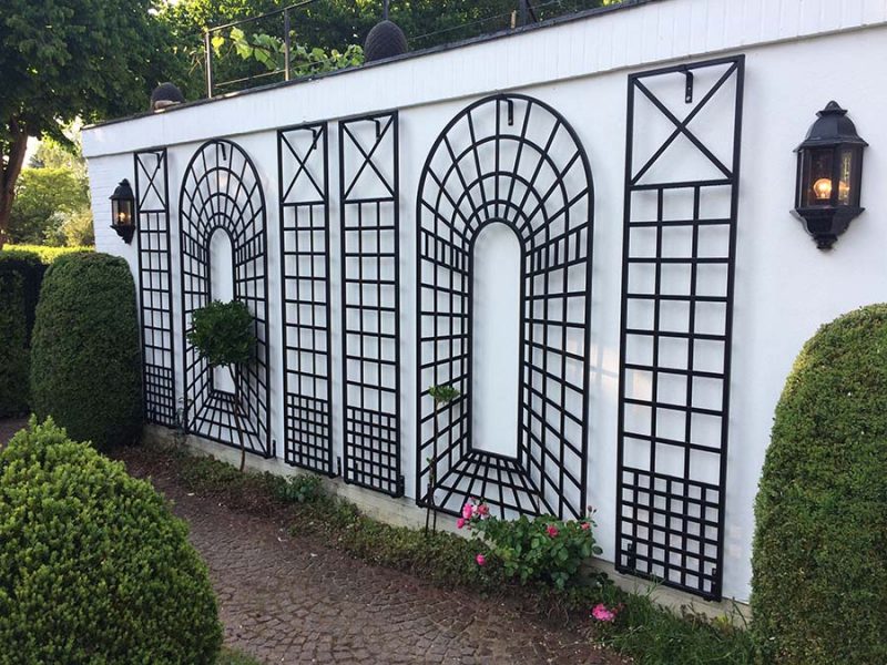 Narrow metal garden trellis with a classic design