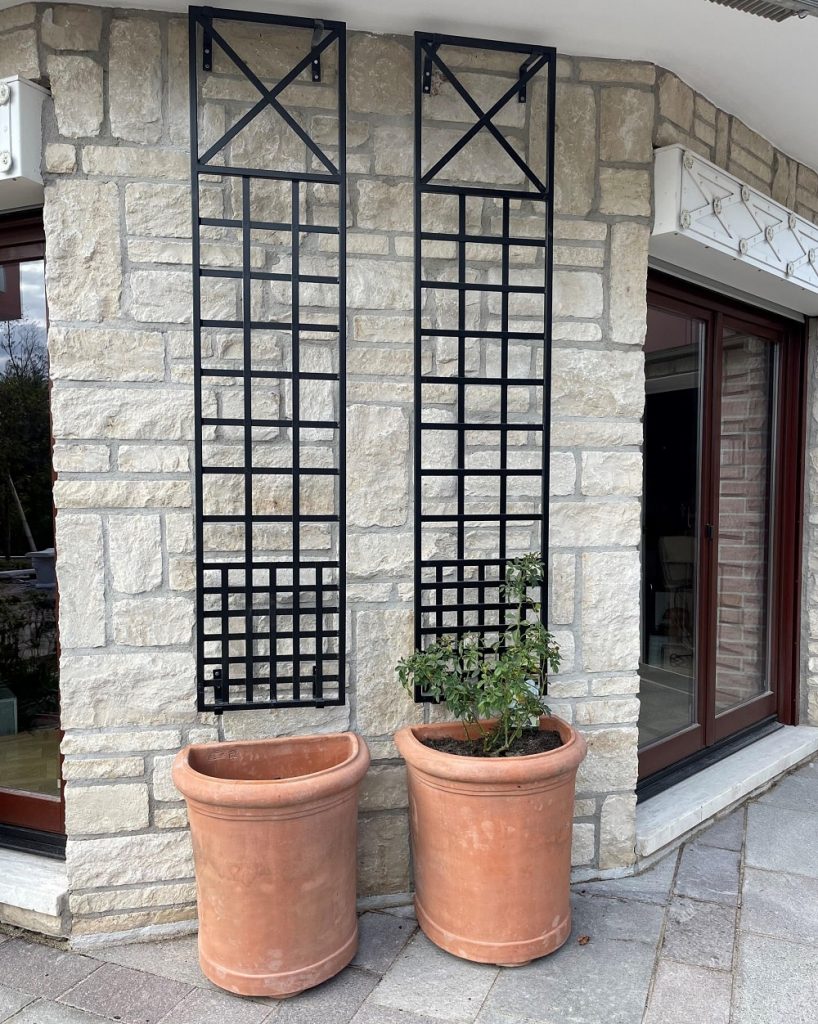 Narrow metal garden trellis with a classic design